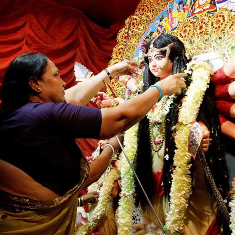 an indian sex worker garlands an idol of hindu goddess durga at a