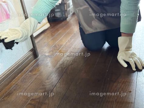 床に手をついて壁を掃除するビニール袋をした手元の写真素材 [249003456] イメージマート