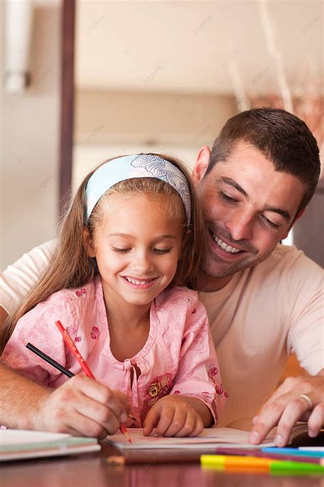 الأب المشرق يساعد ابنتها في كتابة الواجبات المنزلية للواجب المنزلي صورة