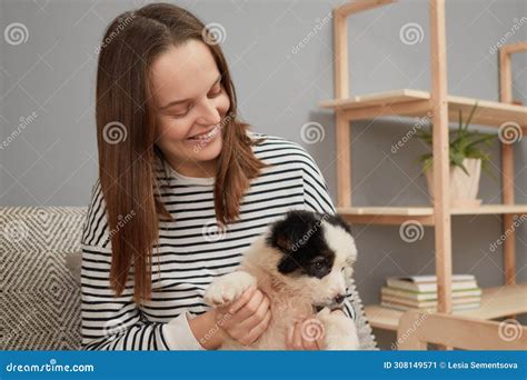 Smiling Cheerful Caucasian Woman Wearing Striped Shirt Sitting With