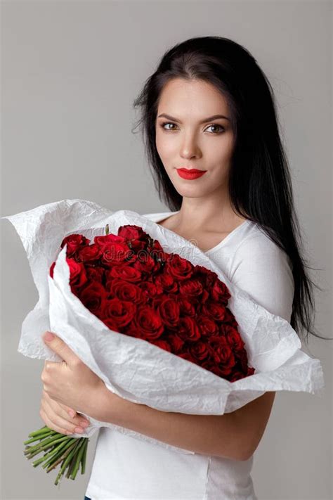 Belle Jeune Femme Avec Un Grand Bouquet Des Roses Rouges Image Stock