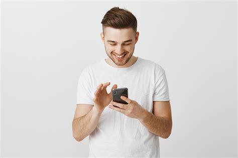 Free Photo Smiling Happy Young Man Using Mobile Phone Messaging With