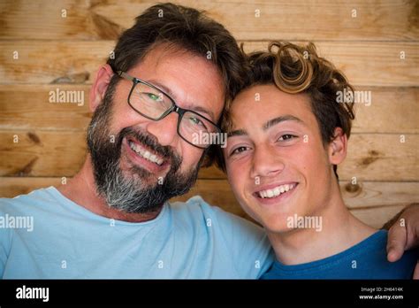 Father And Son Cheerful Portrait With Wood Background Happy Caucasian