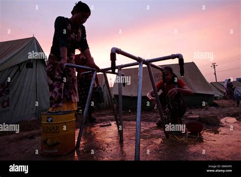 Yazidi Women Filling Drinking Water In Plastic Jerrycans At A Refugee