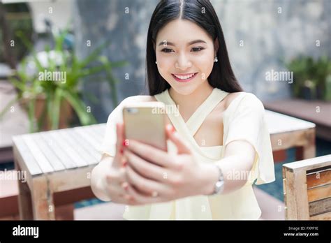 Asian Woman Taking A Selfie With Her Phone In Public Park Focus On Her