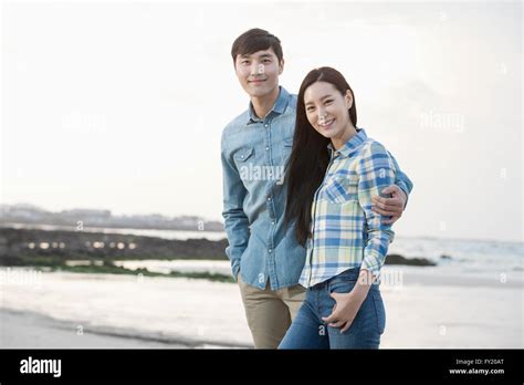 Couple Putting Their Arms Around Each Other And Smiling Forward At The