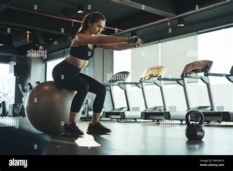 Sporty Woman Doing Workout And Using Fitball By Sitting And Balancing