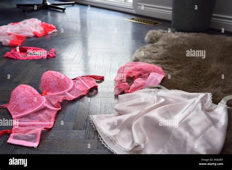 Hot Pink Bra And Womans Undergarment Lingerie Strewn On A Blue Stock