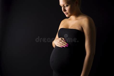 Thoughtful Pregnant Woman Stand With Hands At The Belly Stock Image