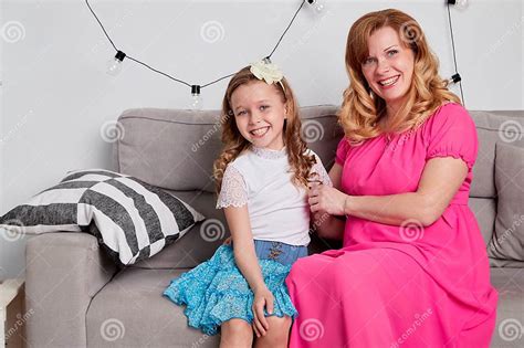 Happy Pregnant Mother And Daughter In Bright Summer Dresses Having