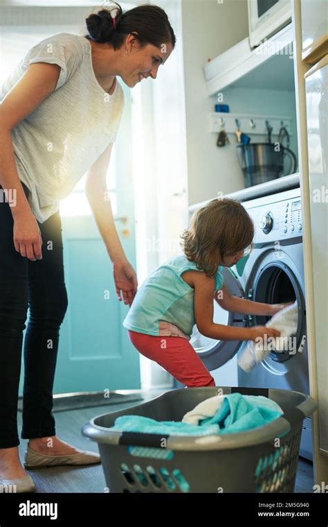 Loading The Washing Machine A Mother And Daughter Using A Washing