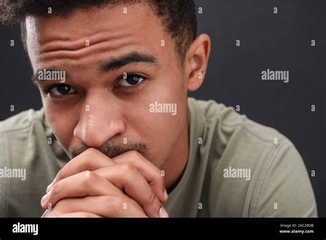 Image Of Focused African American Guy Looking At Camera And Holding