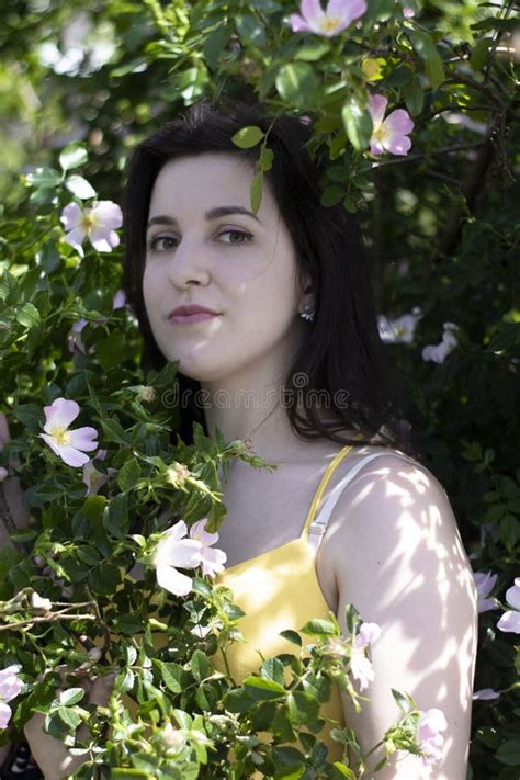 Attractive Young Brunette Woman In Yellow T Shirt In A Bush Full Of