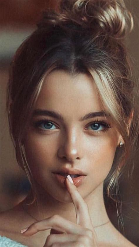A Beautiful Young Woman With Blue Eyes And Blonde Hair Posing In Front