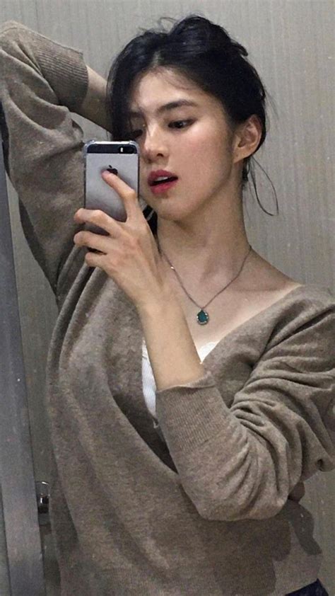 A Woman Taking A Selfie In The Bathroom Mirror With Her Cell Phone Up