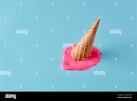Dropped Upside Down Ice Cream Cone With Melting Scoop On Pastel Blue