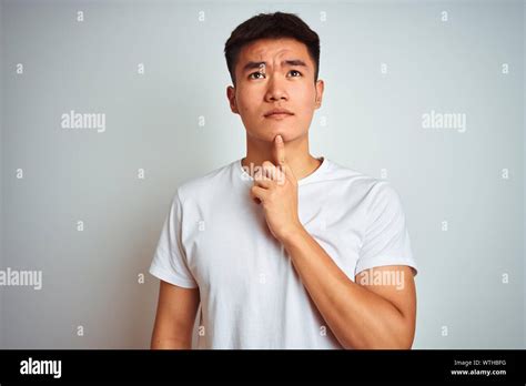 Young Asian Chinese Man Wearing T Shirt Standing Over Isolated White