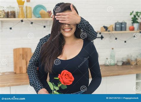 A Young Man Standing Behind His Beautiful Girlfriend With Long Dark