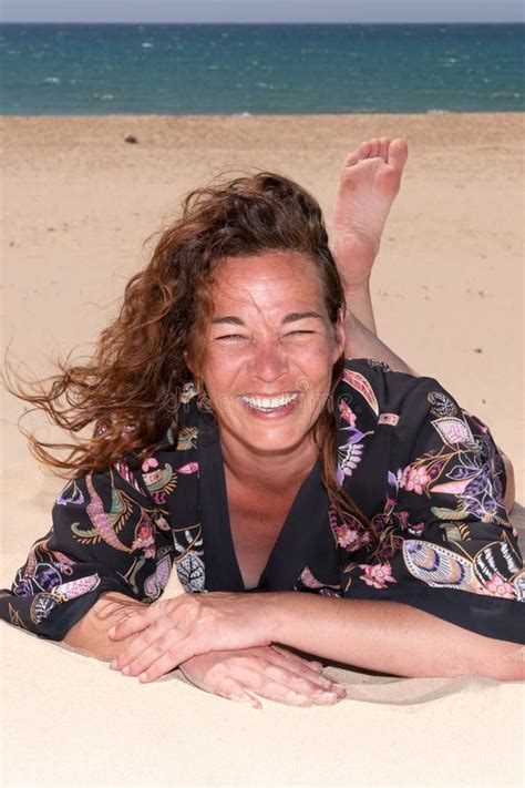 Trendy Brunette Woman On A Sandy Beach Smiling Happy Stock Image
