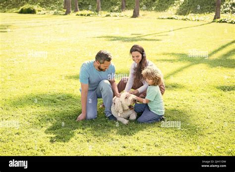 Bonne Famille De Mère Papa Et Enfant Fils Jouant Avec Chien Dans L