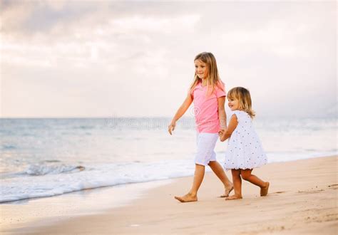 Twee Meisjes Die Samen Op Het Strand In Sunet Lopen Stock Foto Image