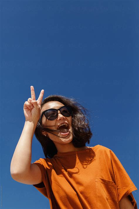 Happy Attractive Asian Woman Showing Peace Sign By Stocksy