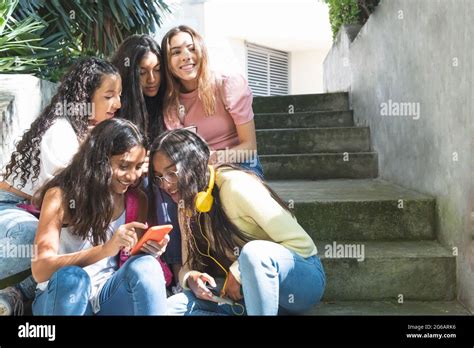 Groupe De Jeunes Filles De Latina Heureux Dans Un Bleacher En Utilisant