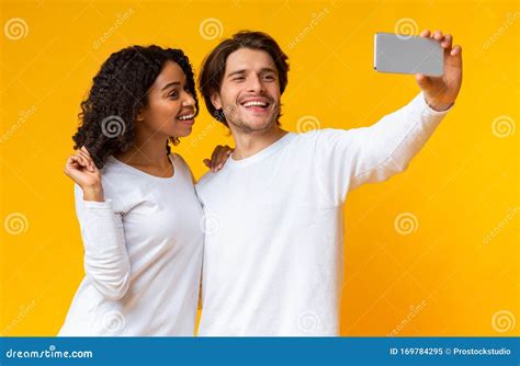 Cheerful Interracial Couple Taking Sellfie On Smartphone Together Stock