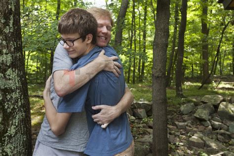 © Caucasian Father And Son Hugging In Forest Stock Image Tetra Images