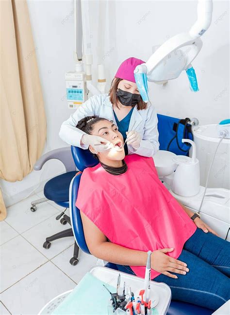 طبيبة أسنان تقوم بفحص أفواه المرضى في مكتب الرعاية الصحية وتنظيف طب