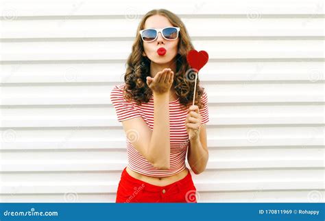 Portrait Beautiful Young Woman With Red Heart Shaped Sunglasses Blowing