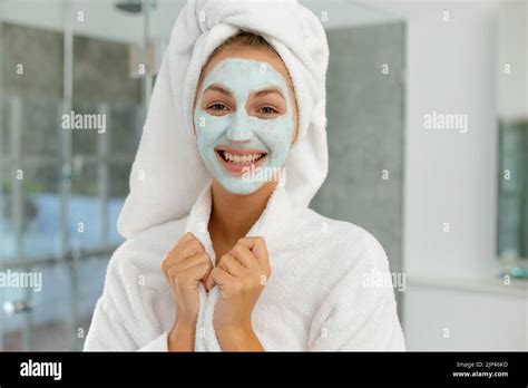 Portrait Of Happy Caucasian Woman Wearing Robe Applying Beauty Face
