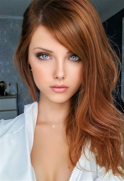 A Woman With Red Hair And Blue Eyes Is Posing For A Photo In A White Shirt