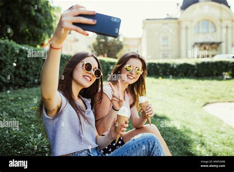 Two Women Friends Take Selfie While Eating Ice Cream Near River At