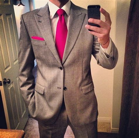 A Man In A Gray Suit And Pink Tie Taking A Selfie With His Cell Phone