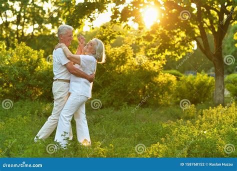Portrait Of Happy Beautiful Senior Couple Dancing In Summer Park Stock