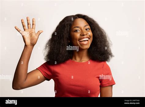 Hello Portrait Of Joyful Young Black Woman Waving Hand At Camera Stock