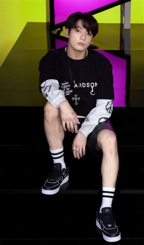 A Young Man Sitting On Top Of A Black Floor Next To A Purple And Yellow