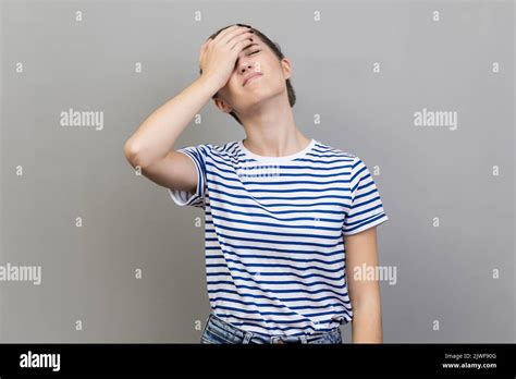 Portrait Of Upset Frustrated Woman Wearing Striped T Shirt Holding