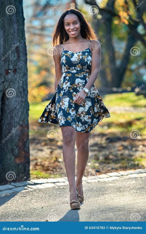 Happy Young African American Woman Walking Outdoors In The City Park