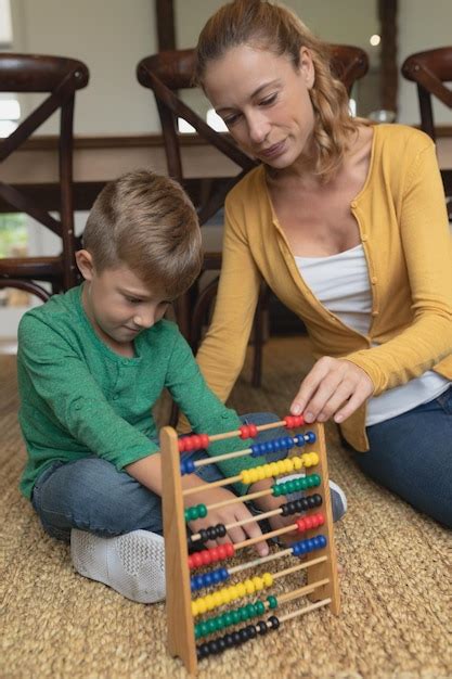 Premium Photo Mother Teaching Her Son Mathematics With Abacus In A