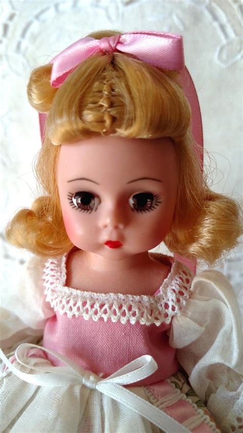 A Doll With Blonde Hair Wearing A Pink Dress