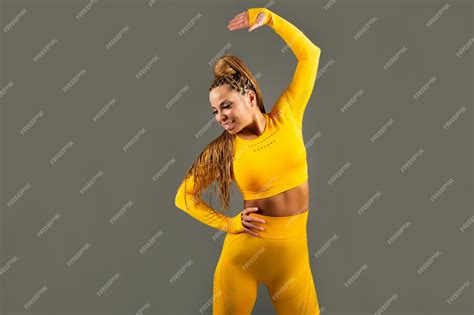 Premium Photo Beautiful Adult Woman In A Yellow Tracksuit On A Gray