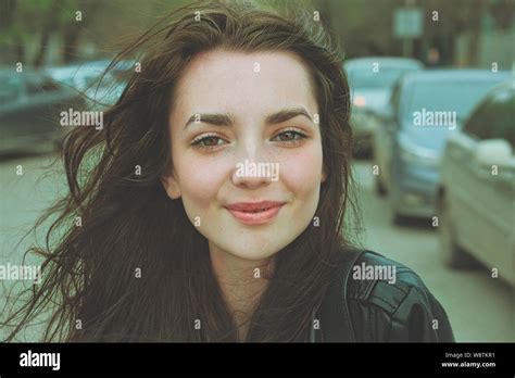 Happy Girl Posing Outside In The Street With Parked Cars On Background
