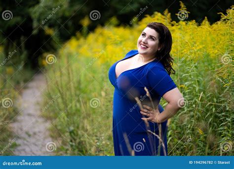Happy Plus Size Fashion Model In Blue Dress With A Deep Neckline