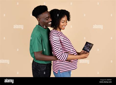Glad Millennial African American Husband Hug Wife With Big Belly Enjoy