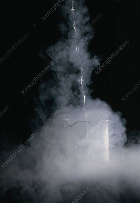 liquid nitrogen being poured into flask stock image