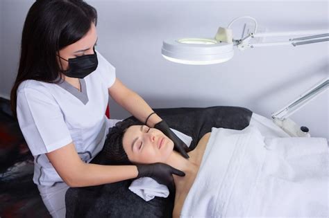 Premium Photo Professional Cosmetologist Doing Facial Massage To