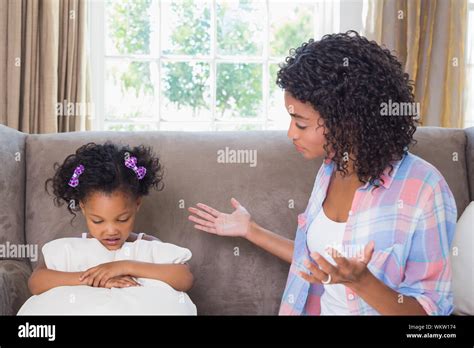 Pretty Mother Scolding Her Daughter On The Couch At Home In The Living
