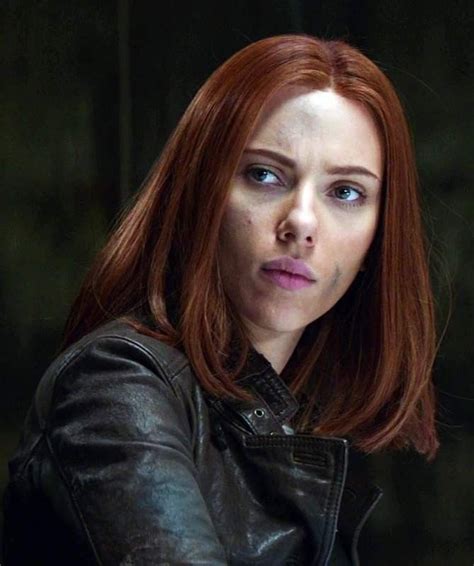 A Woman With Red Hair And Blue Eyes Looks At The Camera While Wearing A